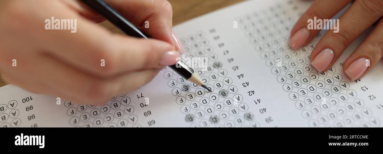 Female student answers test questions with pencil Stock Photo - Alamy