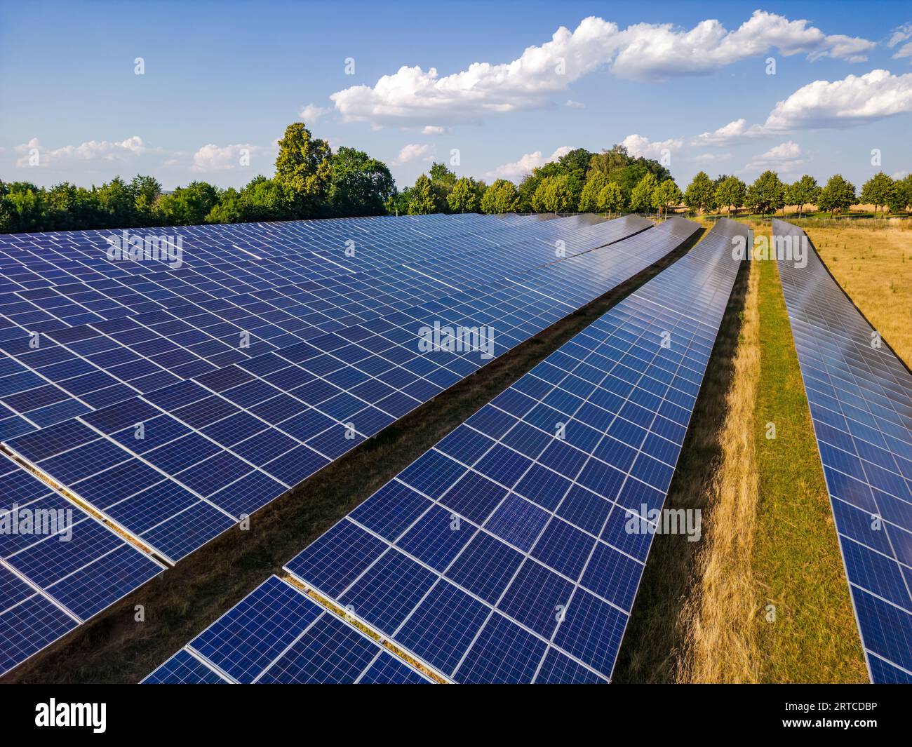A ground mounted system of many solar panels on an open space with ...