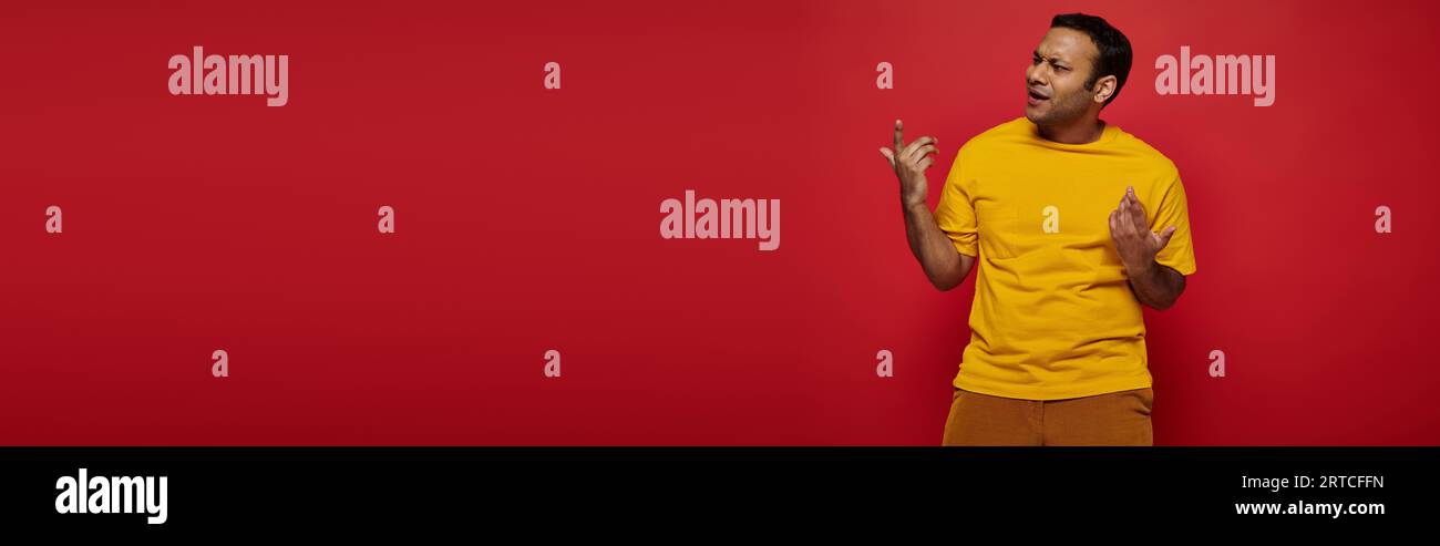 emotional indian man in bright casual clothes gesturing while ...