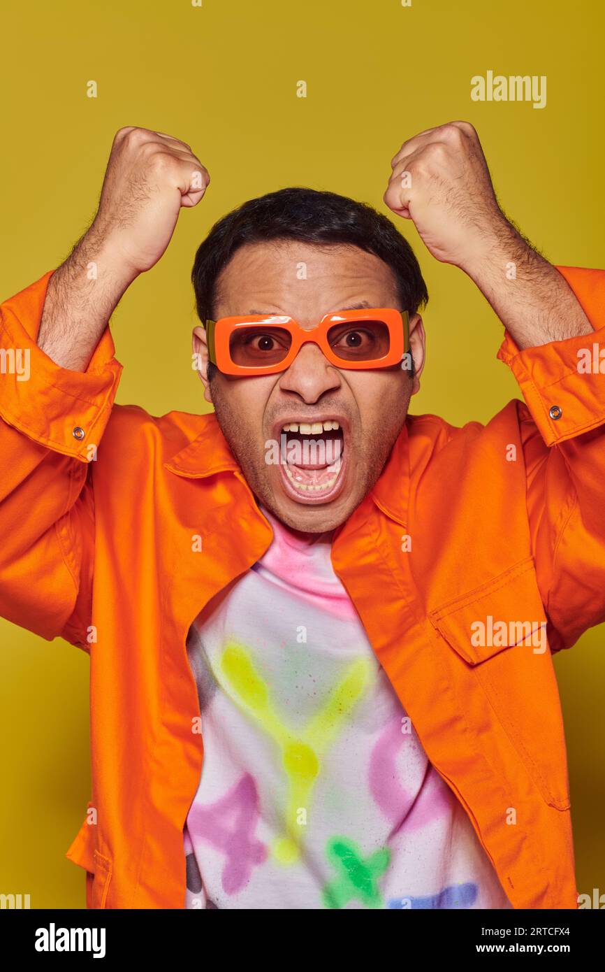 angry indian man in orange sunglasses looking at camera and gesturing ...