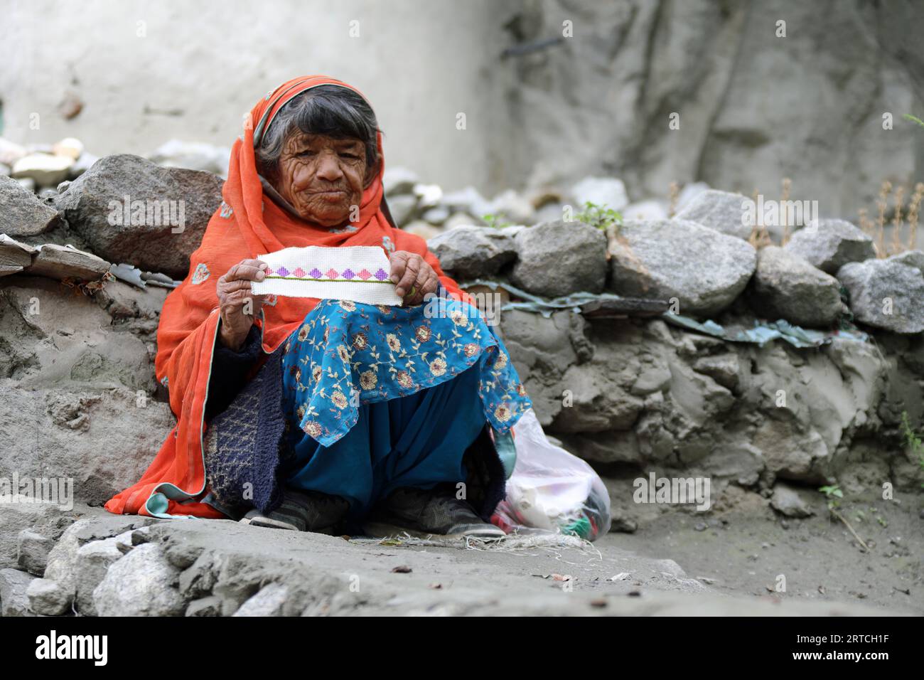 Woman with her sewing at the ancient village of Ganish in the Hunza ...