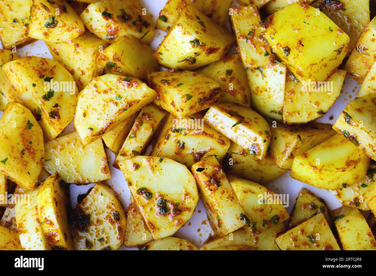 Raw potato slices in spices top view. Fresh potato wedges mixed with ...