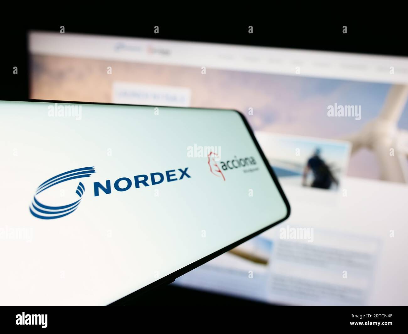 Smartphone with logo of German wind turbine company Nordex SE on screen in front of business ...