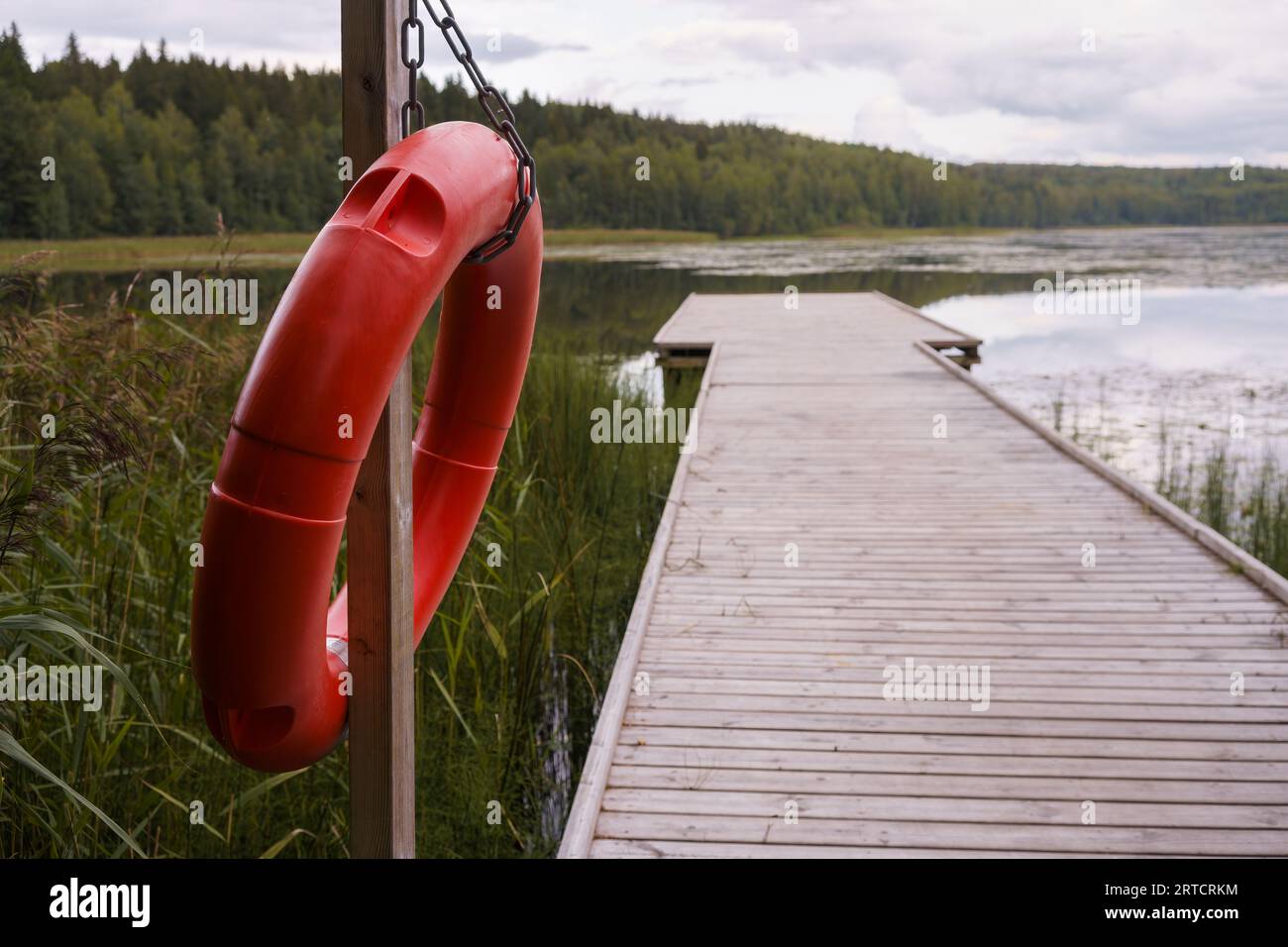 Red life ring buoy hanging from a pole ,next to a wooden pier Stock ...