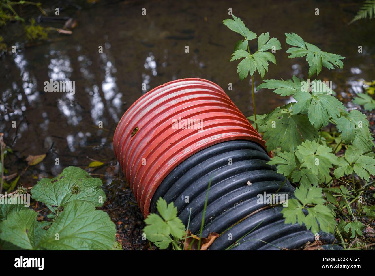 close up view of the PVC drain pipe next to a ditch Stock Photo - Alamy