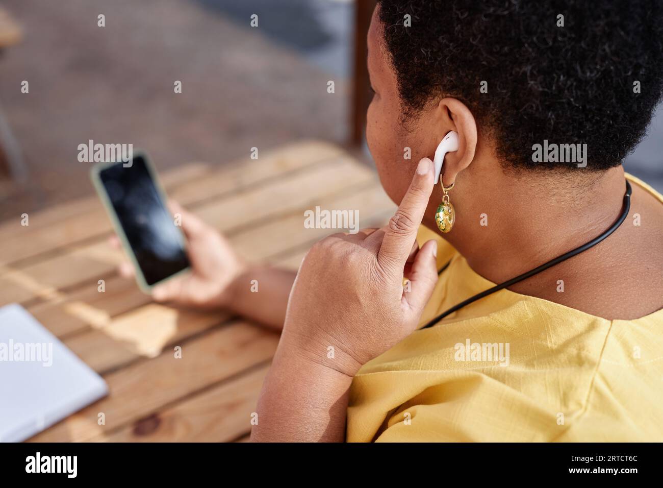 Close up of modern Black senior woman tapping wireless earphones and ...