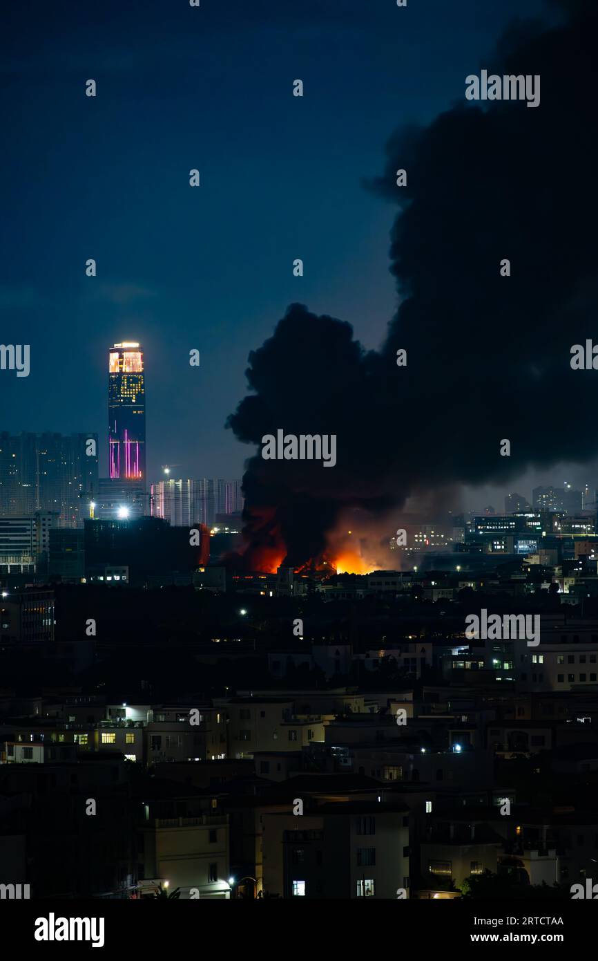 a factory catched a fire with lots dark smoke at night vertical ...