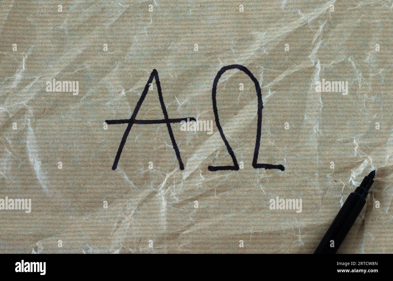 Alpha and Omega letters handwritten on crumpled paper with black marker ...