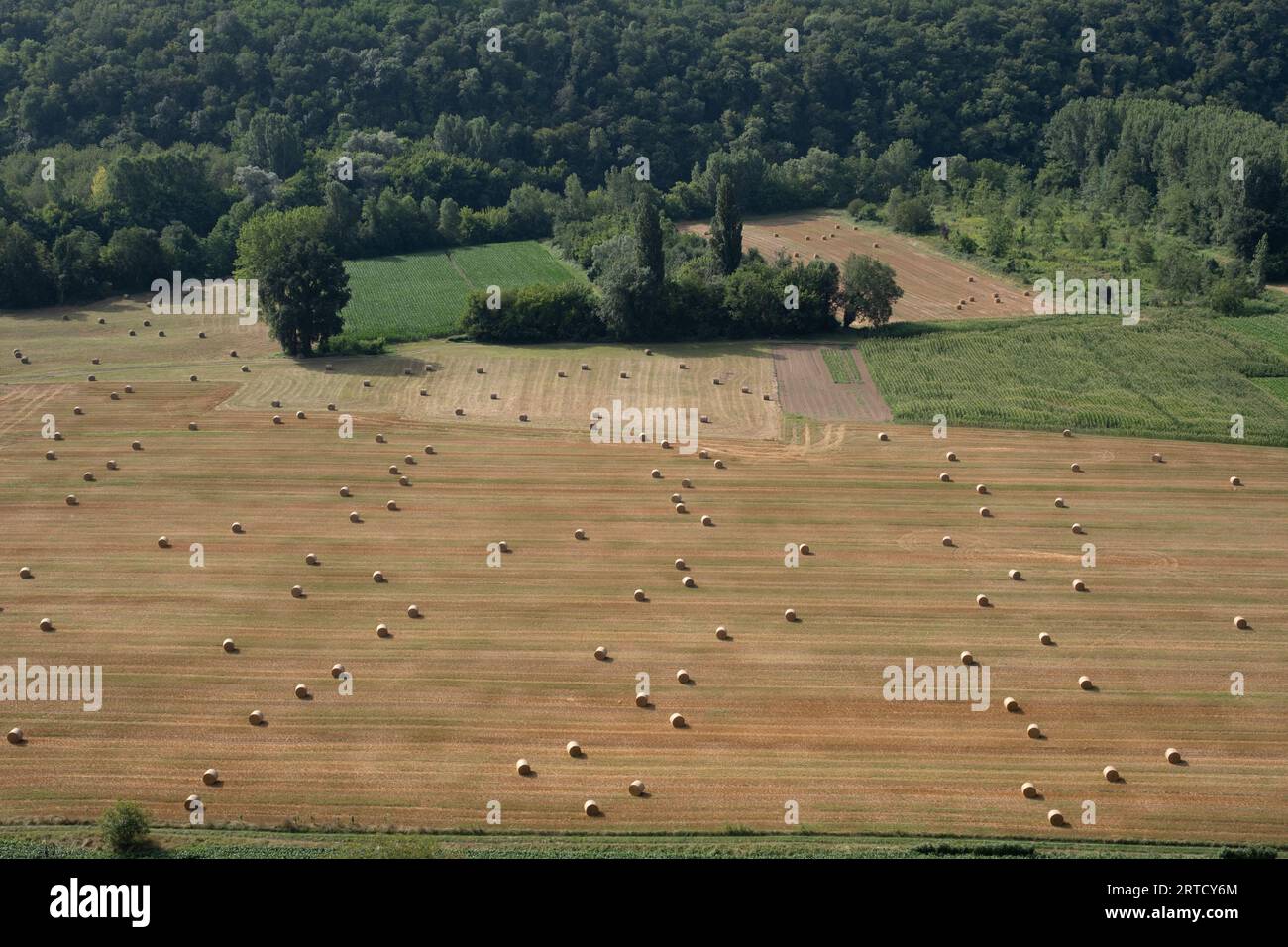 Patchwork fields with hay bales scattered around in the Dordogne Valley ...