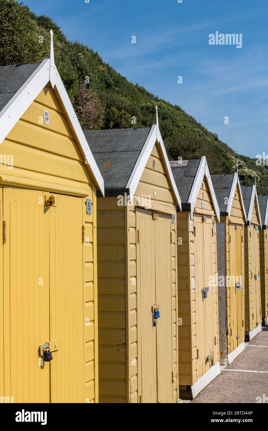 row of colourful yellow painted beach huts on the sea front at boscombe ...