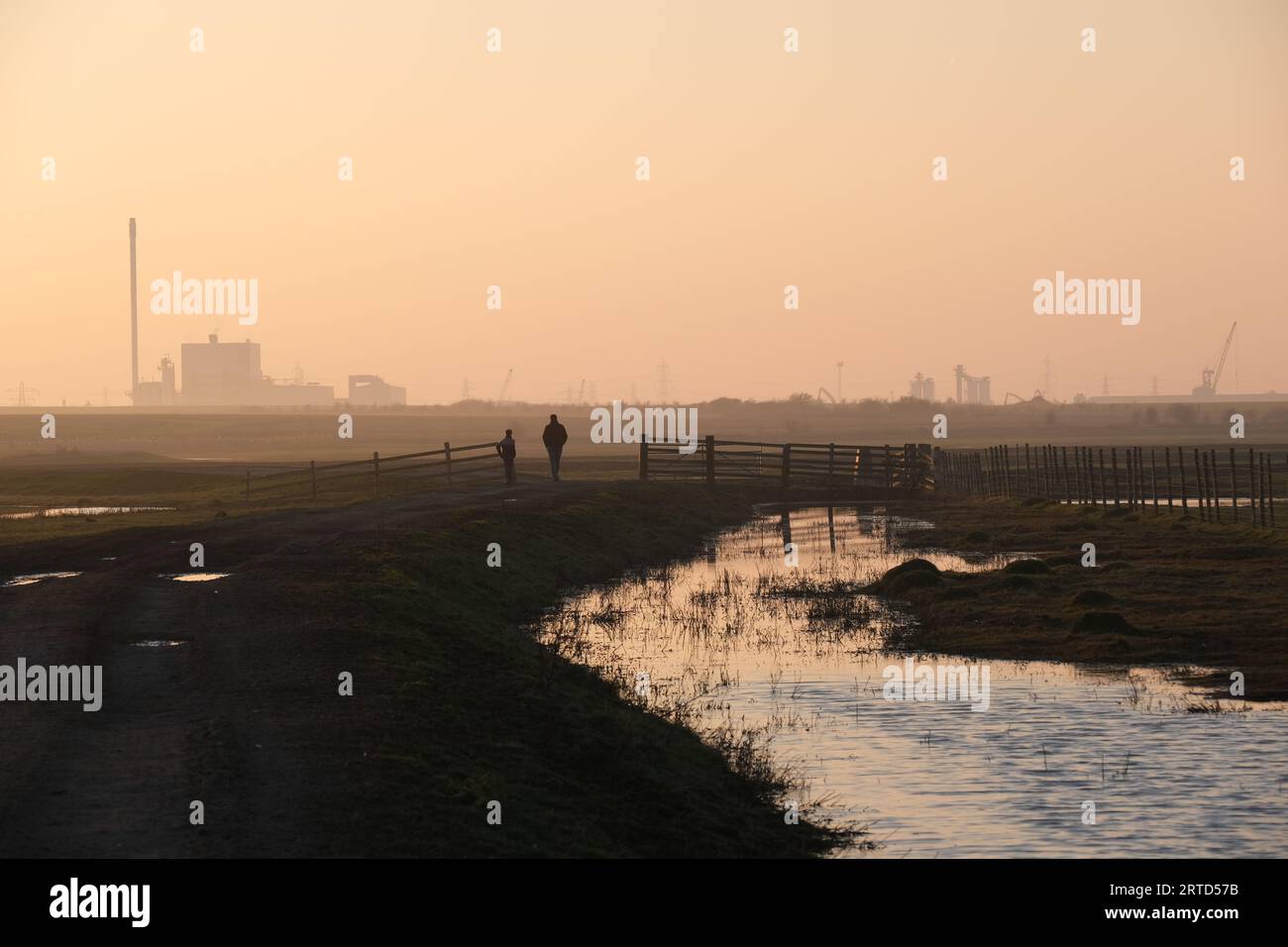 People walking at Elmley Nature Reserve with the Cement Worksin the ...