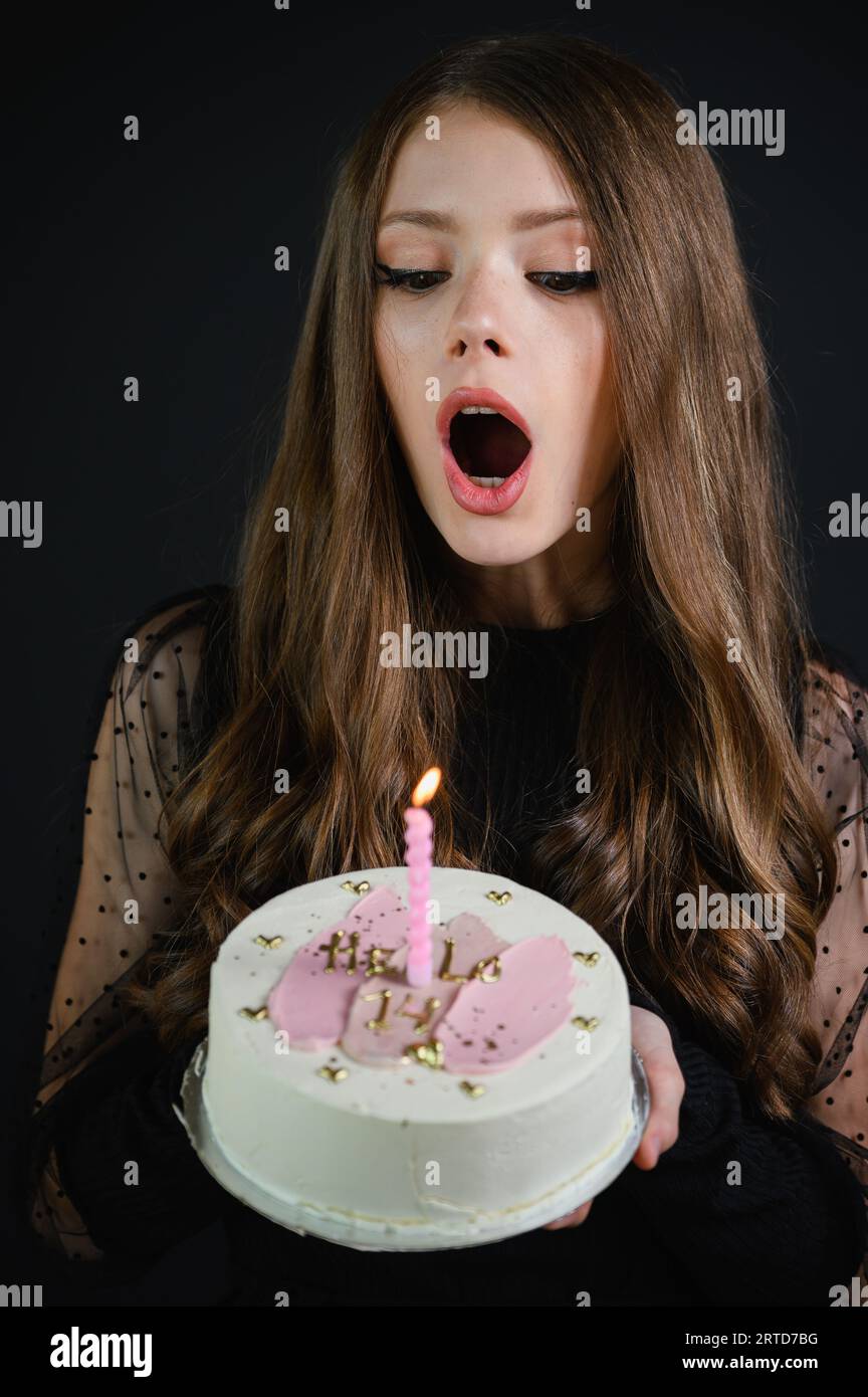 Beautiful Happy Teen Girl Wearing Black Dress Blowing Out A Candle On A