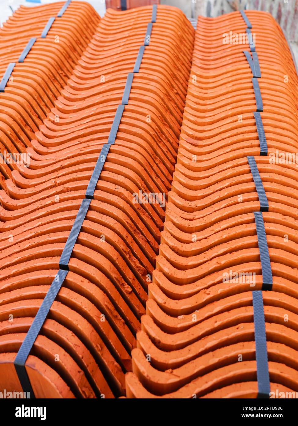 Packed in rows new red brown roof fired clay tiles, delivered to a ...