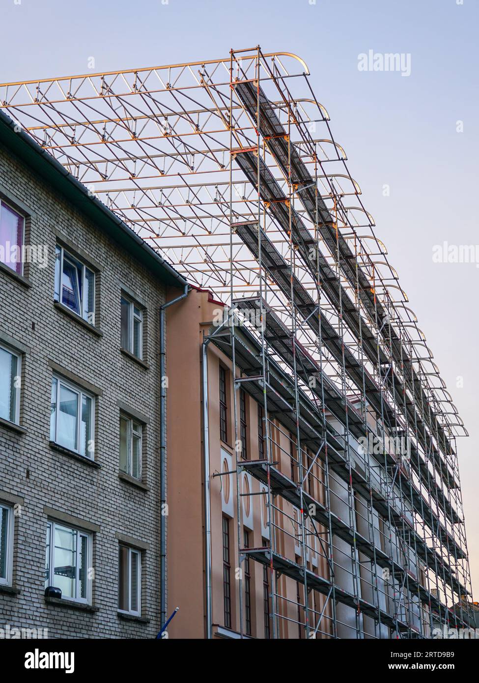 High scaffold for temporary roof being erected around a building to re ...