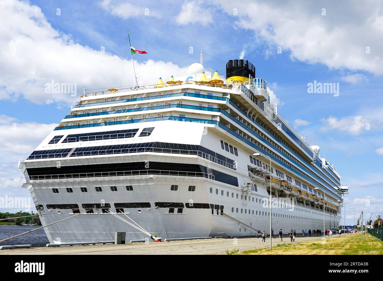 Large white cruise ship with tourists at harbour terminal, rear view ...