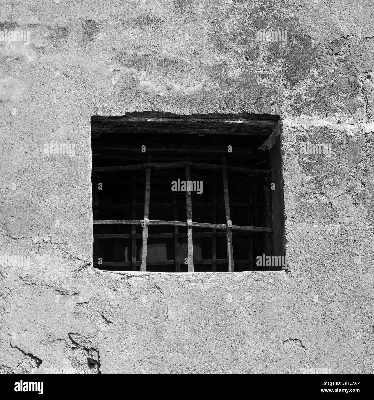 Window with lattice in old building. One small square window closed ...