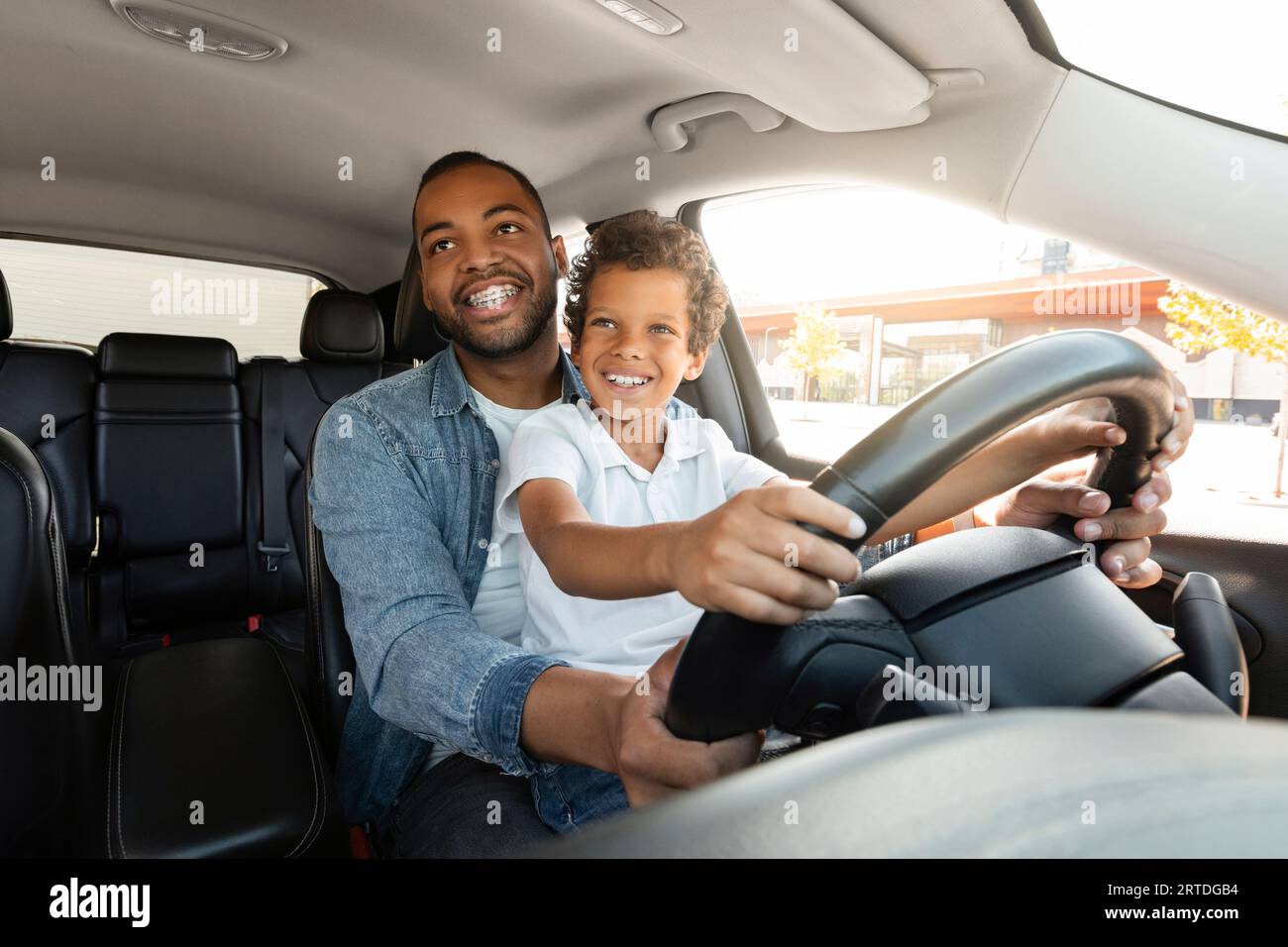 Happy african american father and son driving car together Stock Photo ...