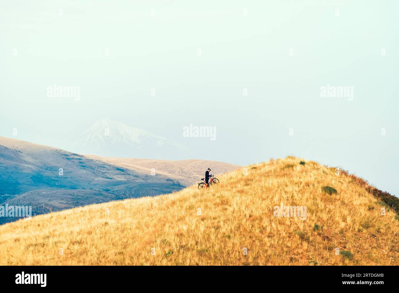 Caucasian male cyclist push bicycle uphill in armenia mountains ...