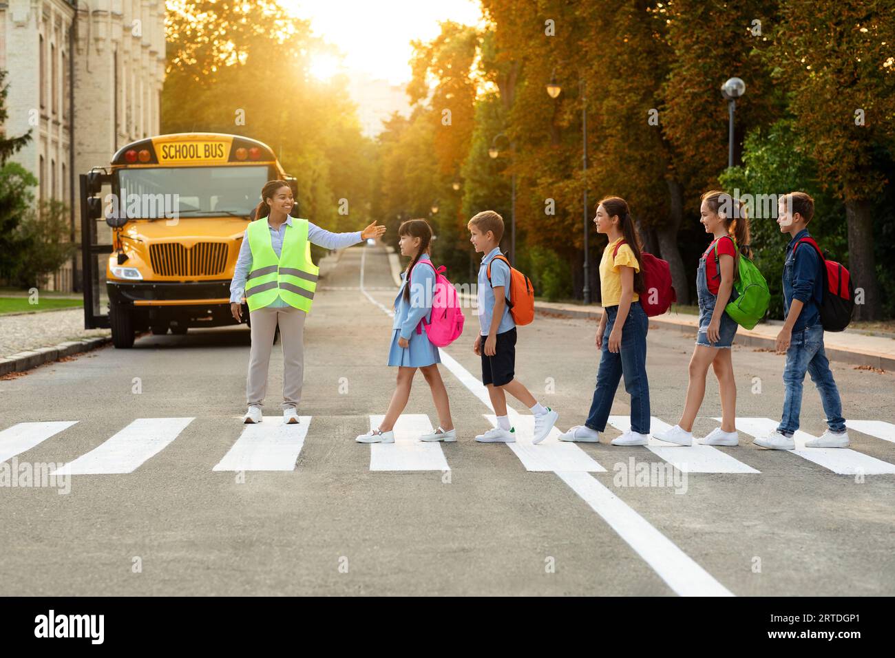 Road Traffic Safety. School Bus Assistant Helping Kids Cross Road By ...
