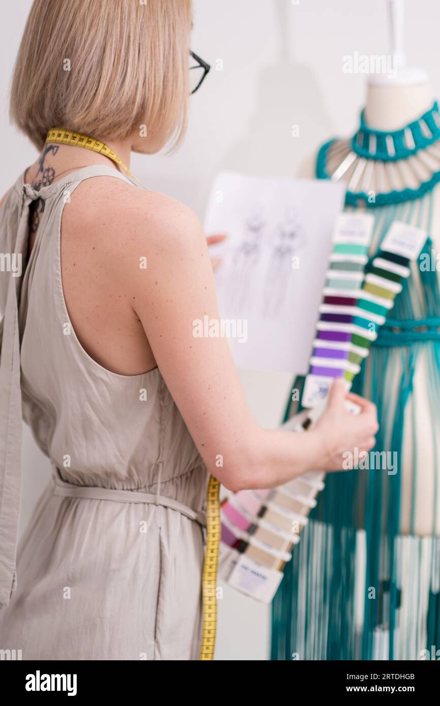 Fashion designer with color swatch and outfit sketch learns works in ...