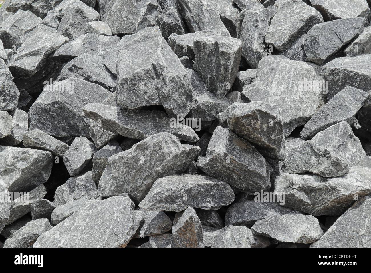 A view of a pile of medium sized black granite pieces stacked in an ...