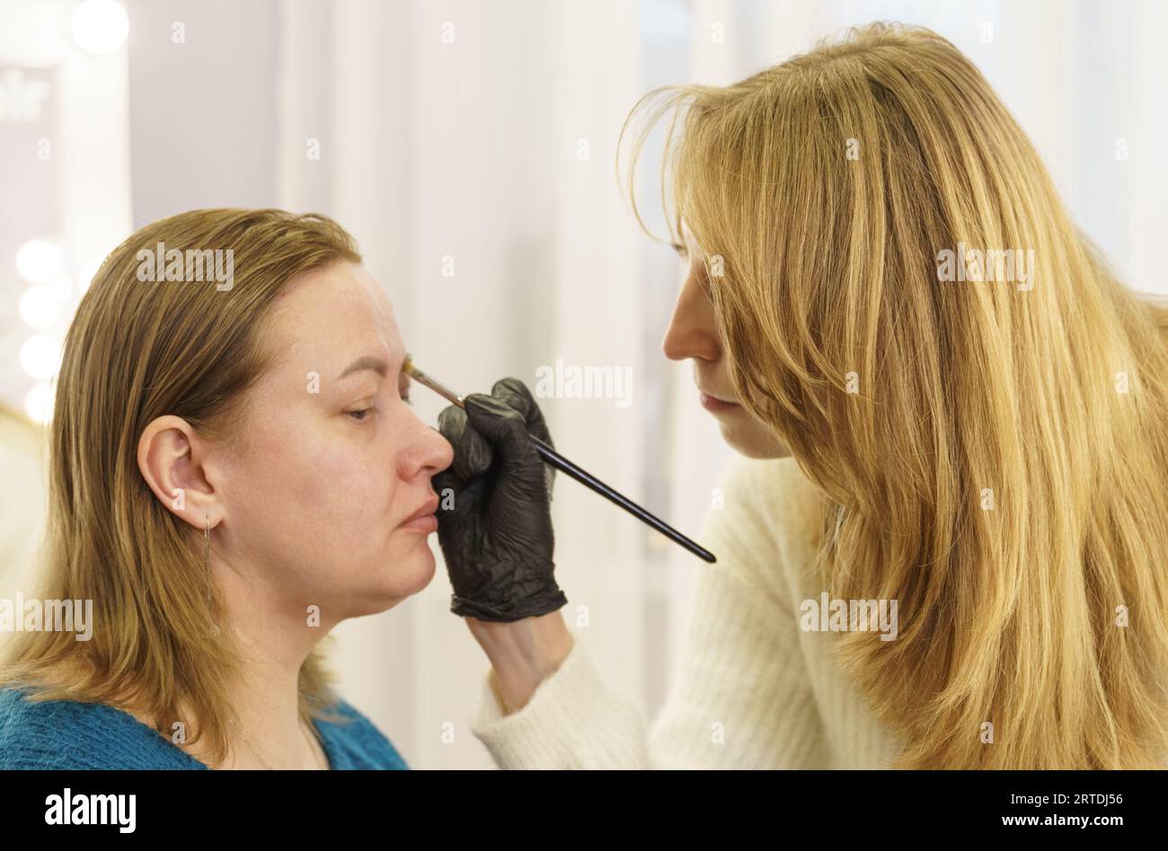 The master draws the shape of the eyebrows with white paint before ...