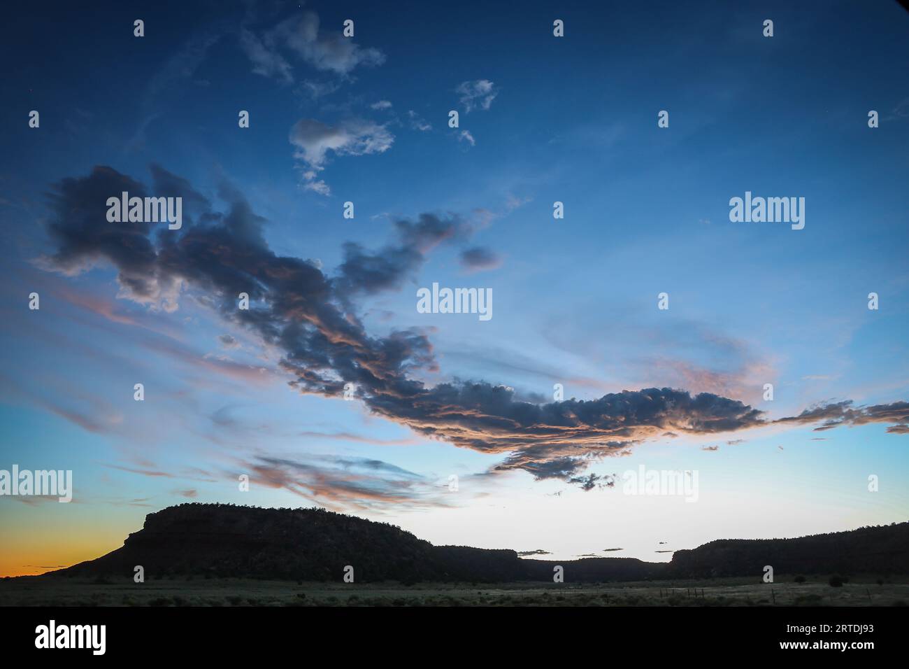 A silhouetted rock formation against a dark night sky, creating a ...