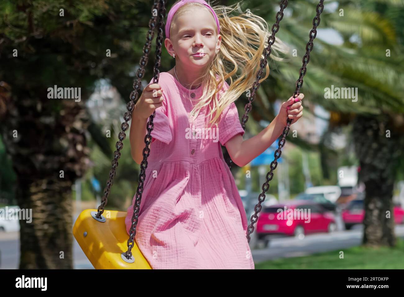 A lively kid embraces swing fun at the urban park playground Stock ...
