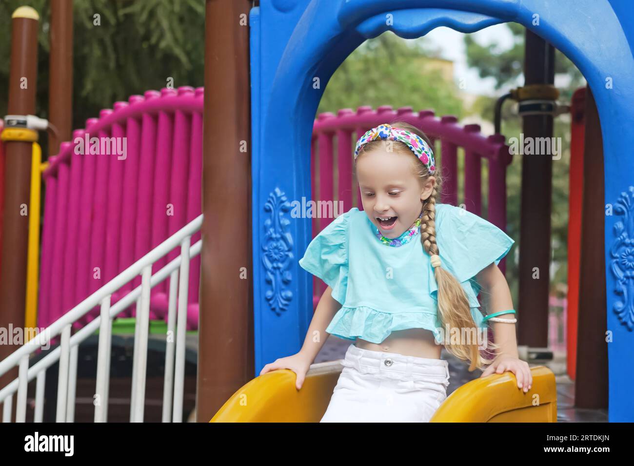 Energetic child joyfully explores maze slide on the playground Stock ...