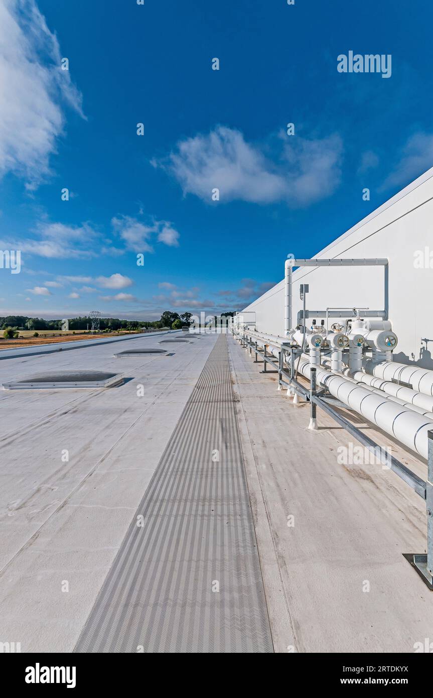 White insulated piping mounted on roof of cold storage facility, for ...
