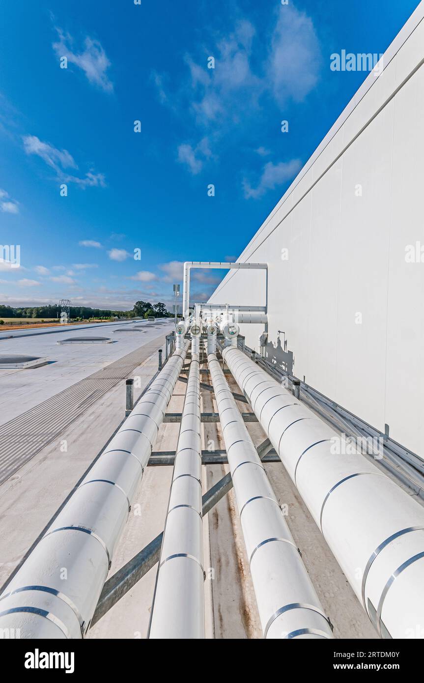 White insulated piping mounted on roof of cold storage facility, for ...