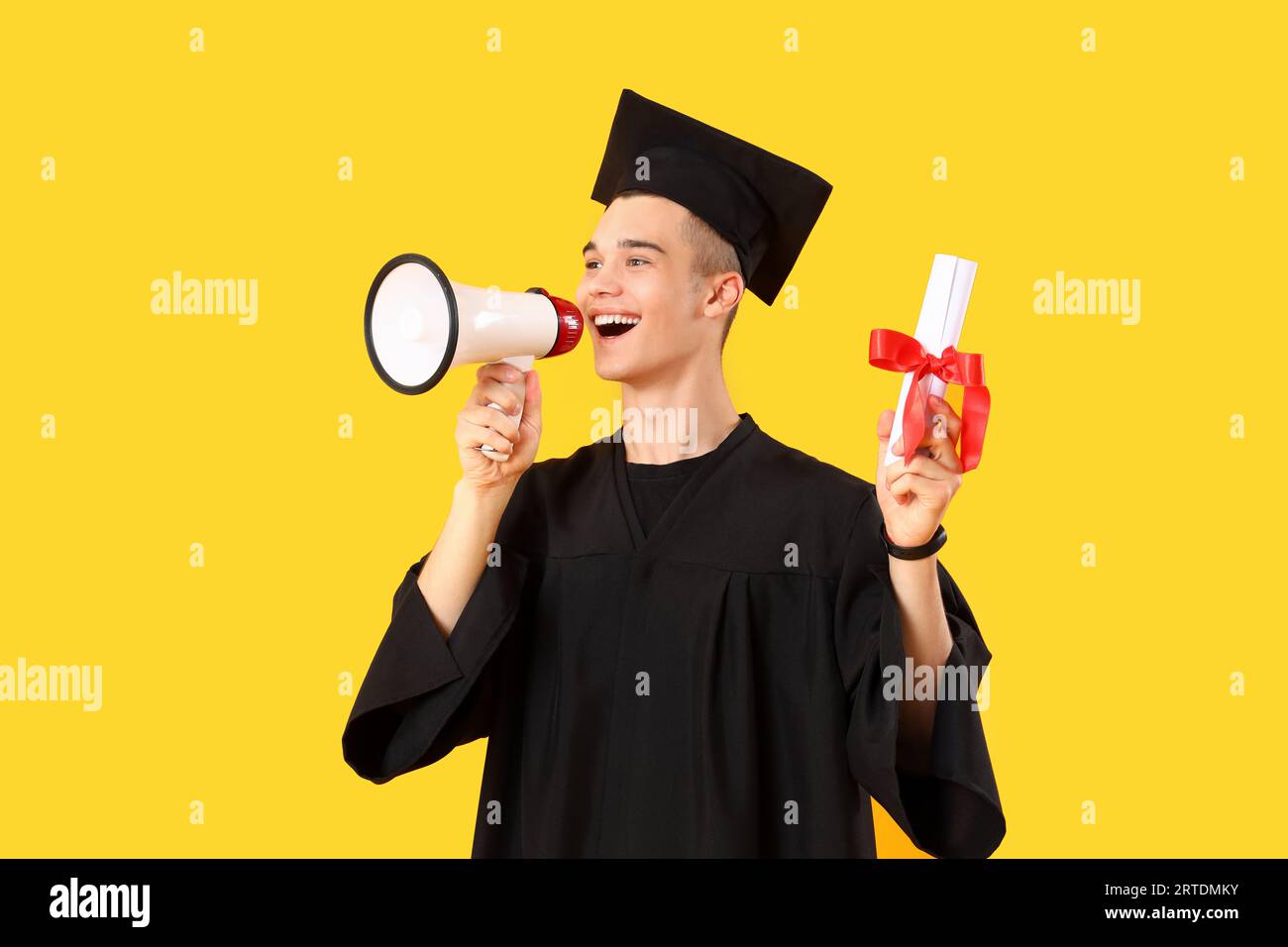 Male graduate student with diploma shouting into megaphone on yellow ...