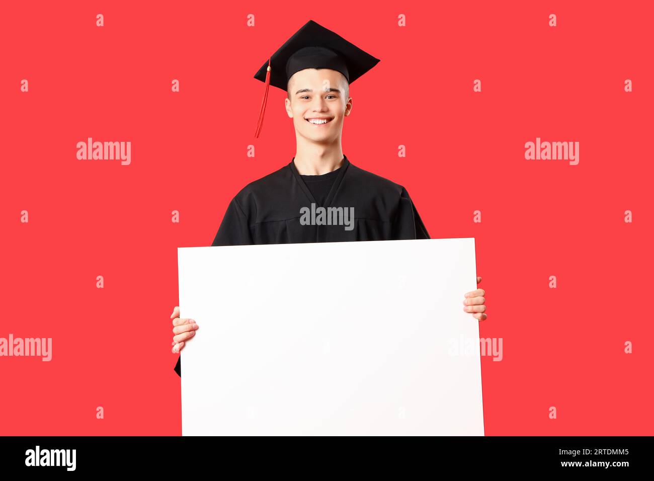 Male graduate student with blank poster on red background Stock Photo ...