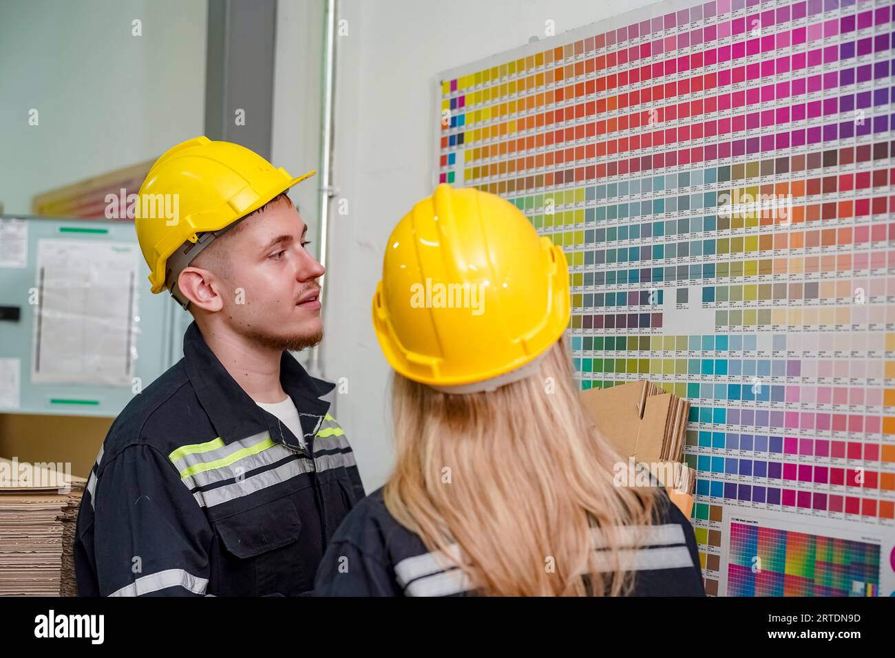 Industrial worker indoors in factory. Young technician with orange hard ...