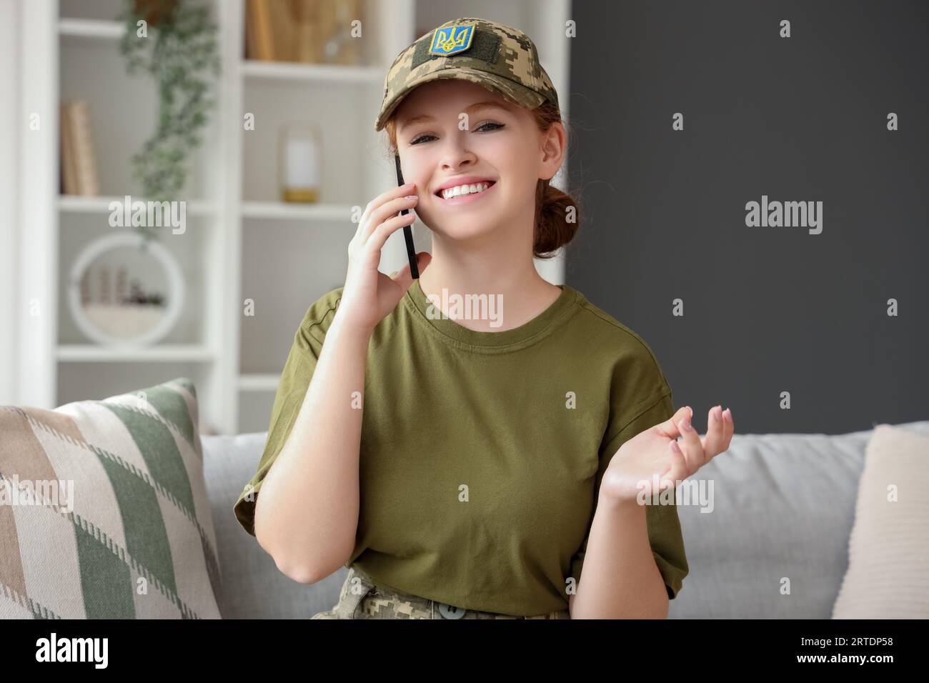 Young female soldier talking by mobile phone at home Stock Photo - Alamy