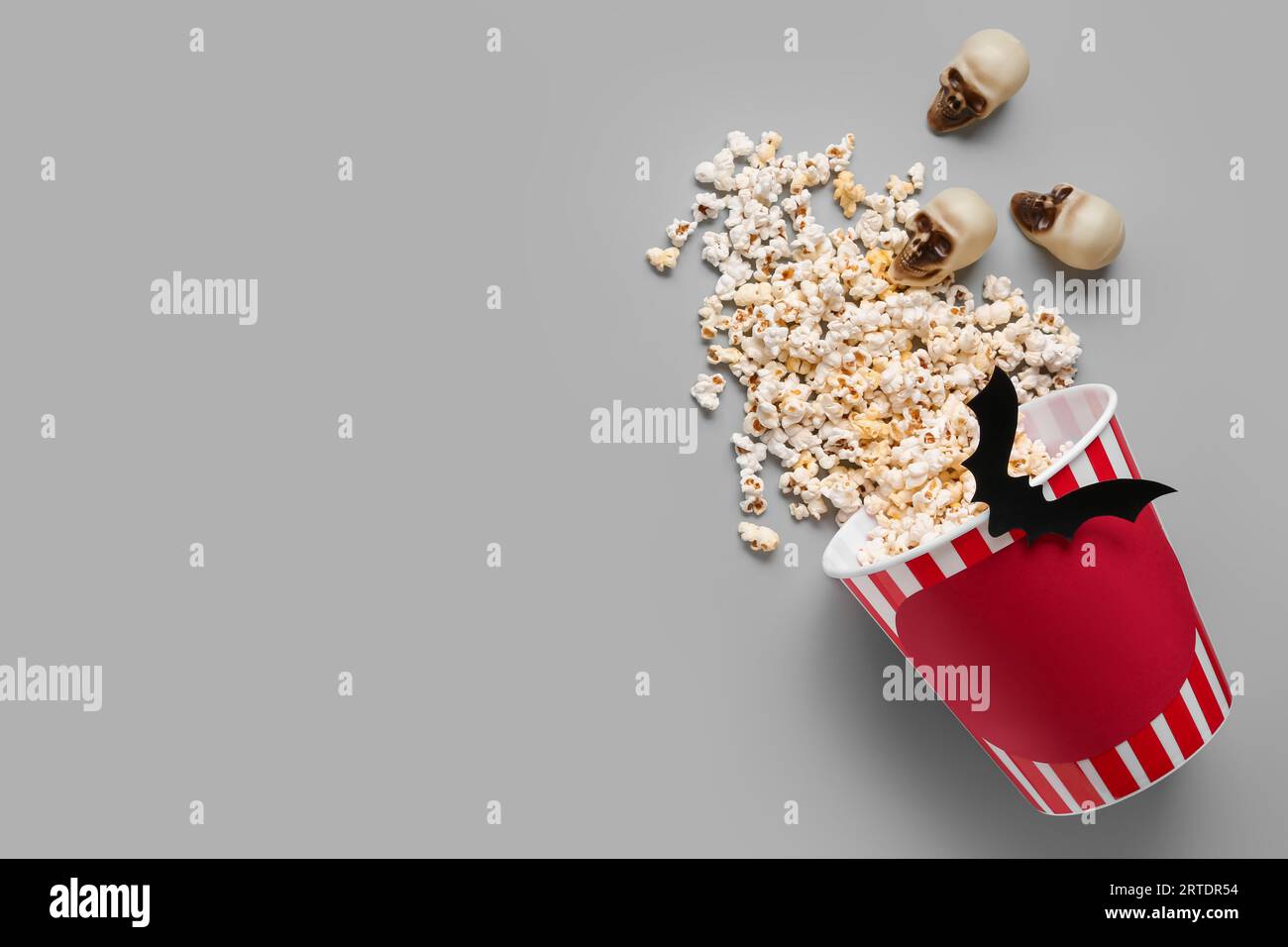 Bucket with tasty popcorn, skulls and paper bat for Halloween ...