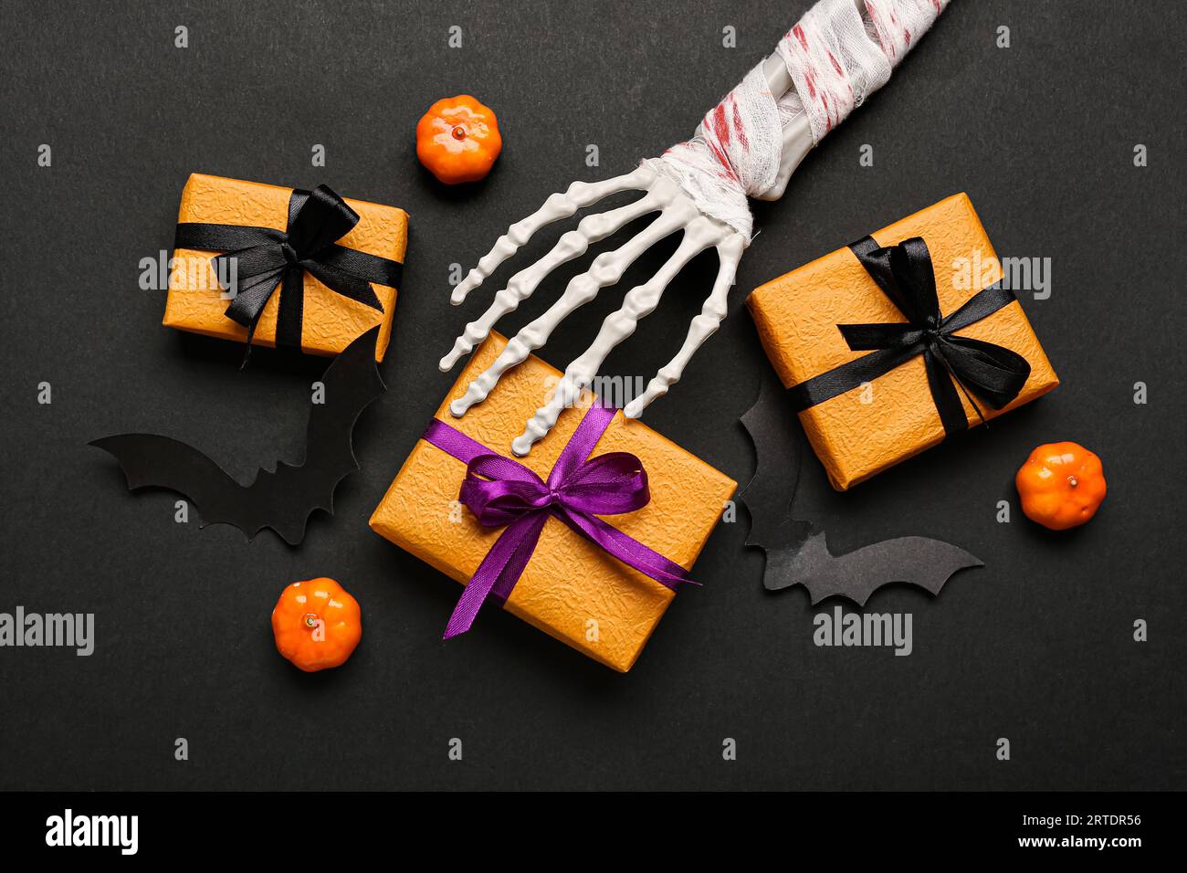 Composition with gift boxes, skeleton hand and Halloween decoration on ...