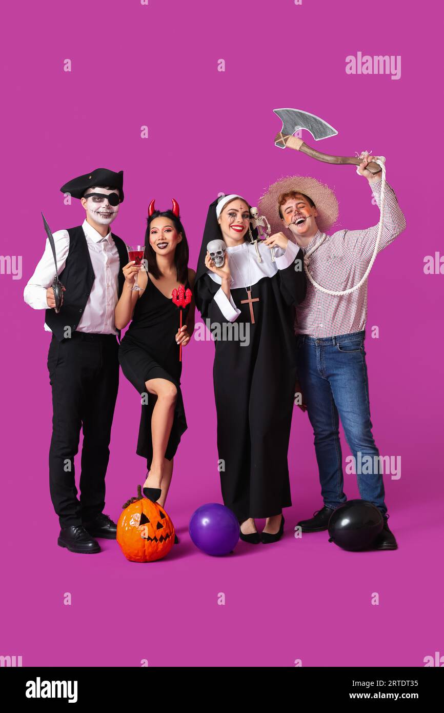 Group of friends in costumes for Halloween party with balloons on color ...