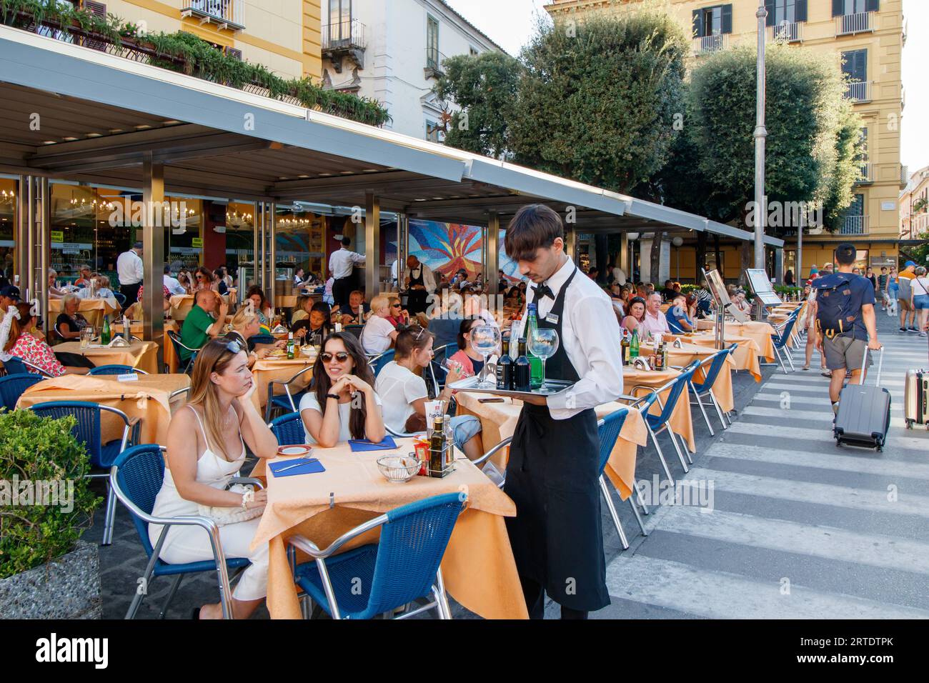 A waiter serving customers seated at The Fauno Bar and restaurant ...