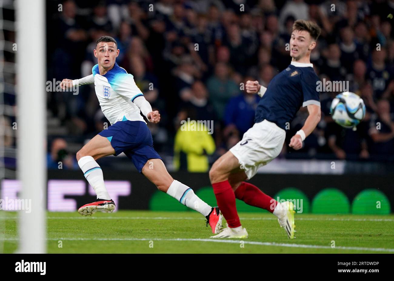 England’s Phil Foden crosses the ball past Scotland’s Kieran Tierney ...
