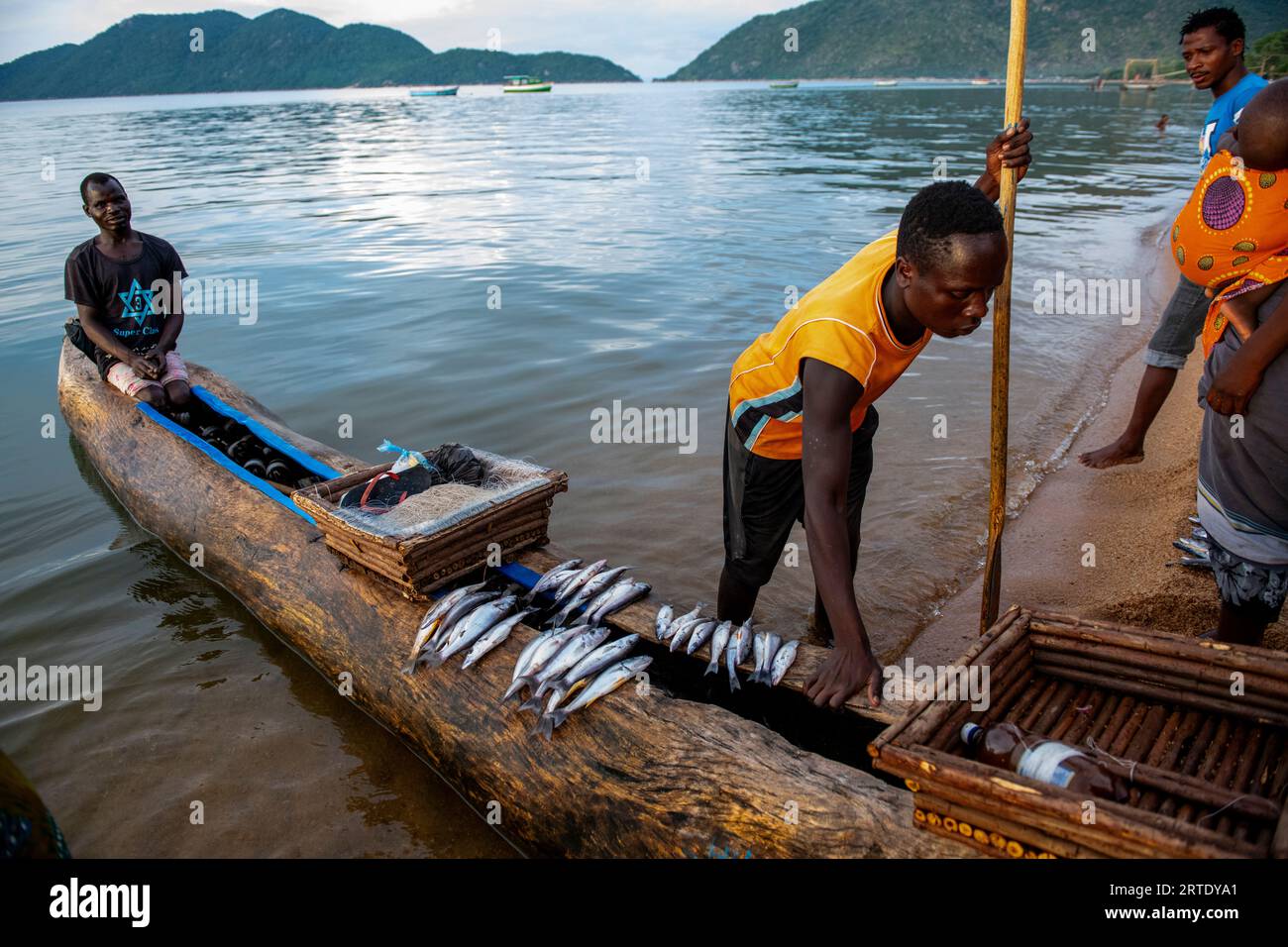 Cape Maclear, Malawi. Fishermen dock their boat after catching several ...