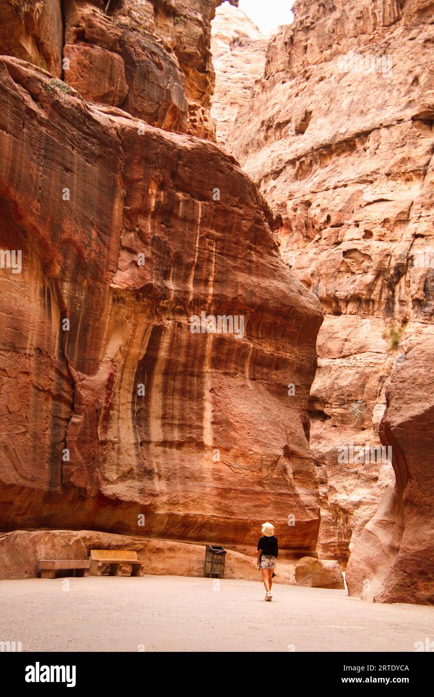 Caucasian tourist woman walk at Petra entrance canyon al-siq tunnels ...