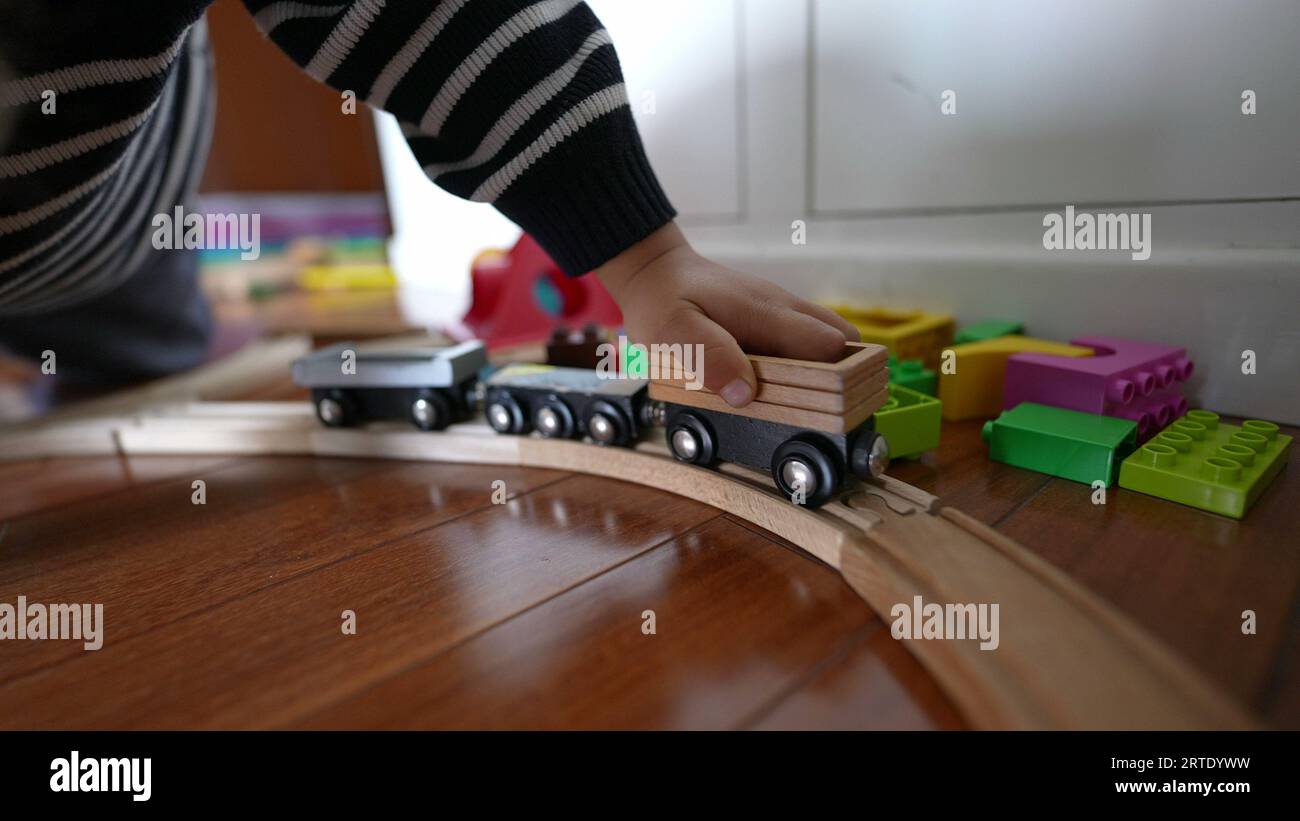 Little boy playing with vintage wooden train tracks, child immersed in ...