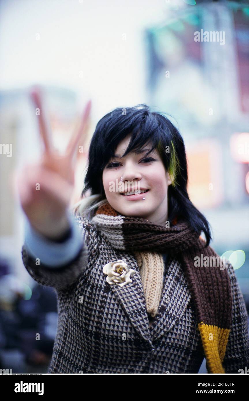 Portrait of Girl Giving Peace Sign Stock Photo - Alamy