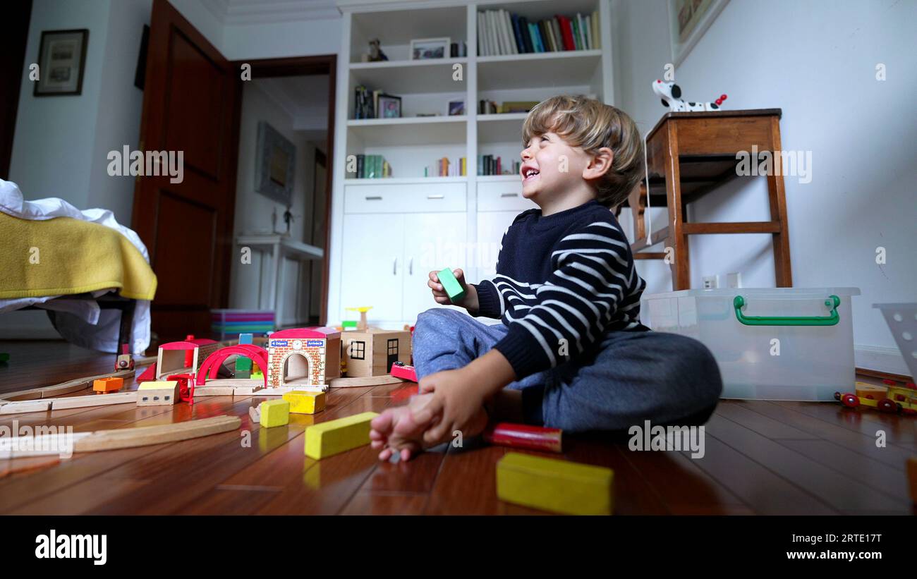 Happy child playing with tower blocks. One small boy putting vintage ...