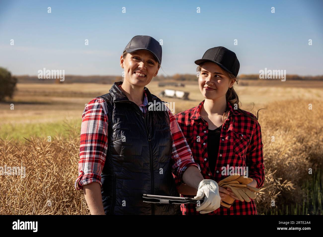 Close-up portrait of a woman farmer and her apprentice standing in the ...