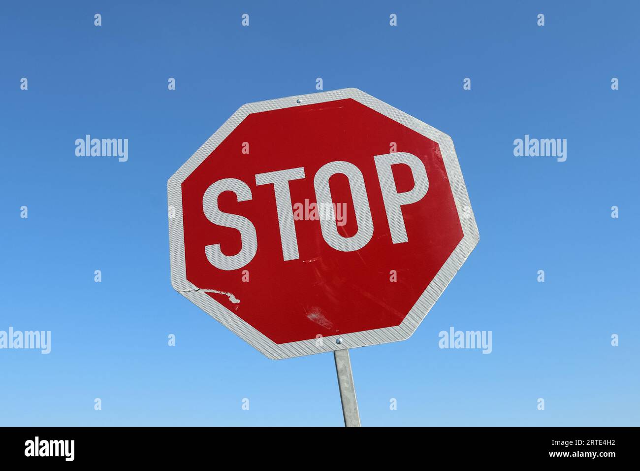 Close Up Of A Stop Sign Against A Clear Blue Sky Stock Photo - Alamy