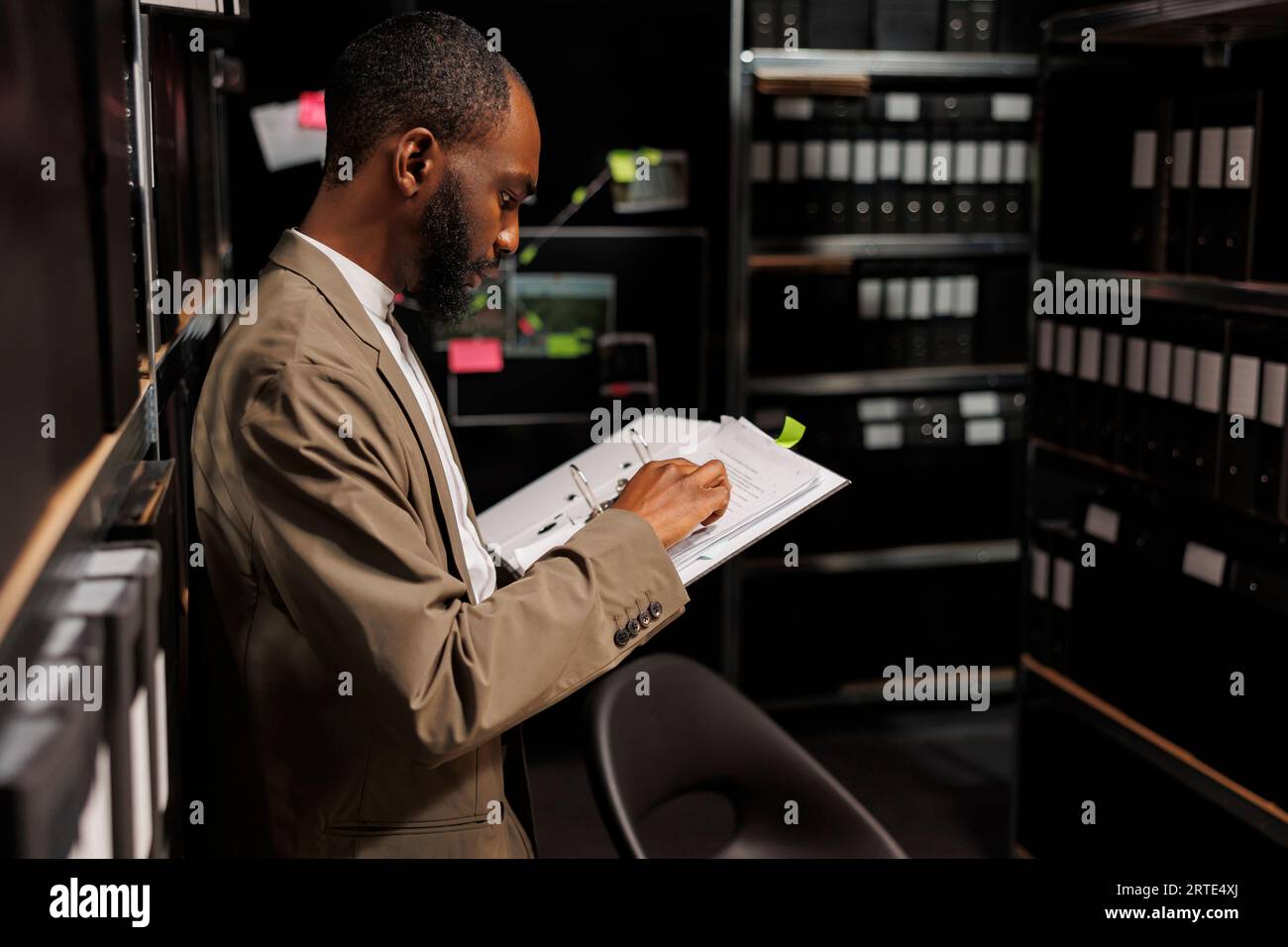 Investigator studying folder with police records in archive in office ...