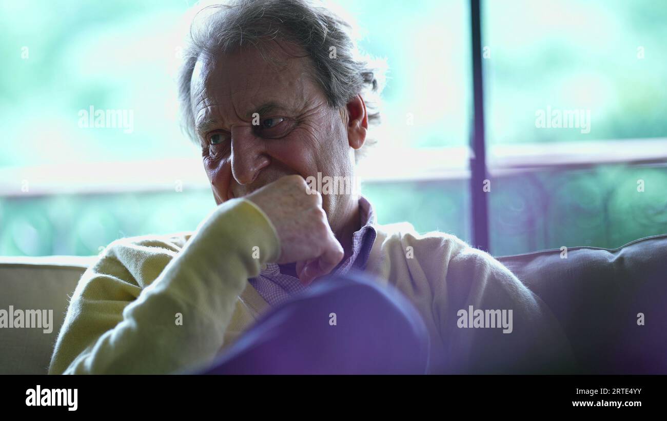 Thoughtful senior man reflecting on decision while scratching eye and ...