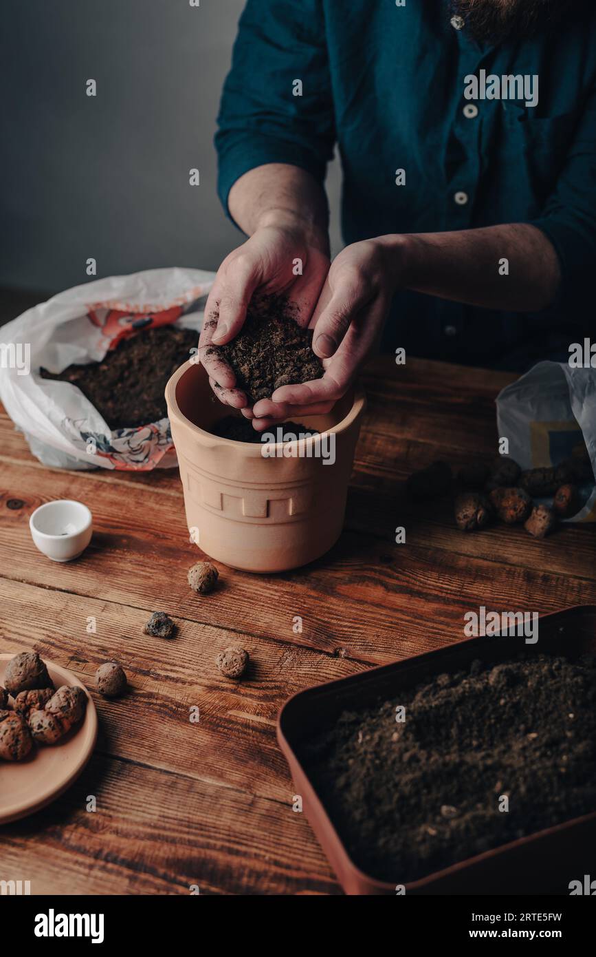 Man Putting Soil into Terracotta Pot for Sowing Houseplant Seeds Stock ...